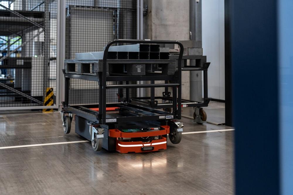 Mobile robots move material stored on pallets from station to station