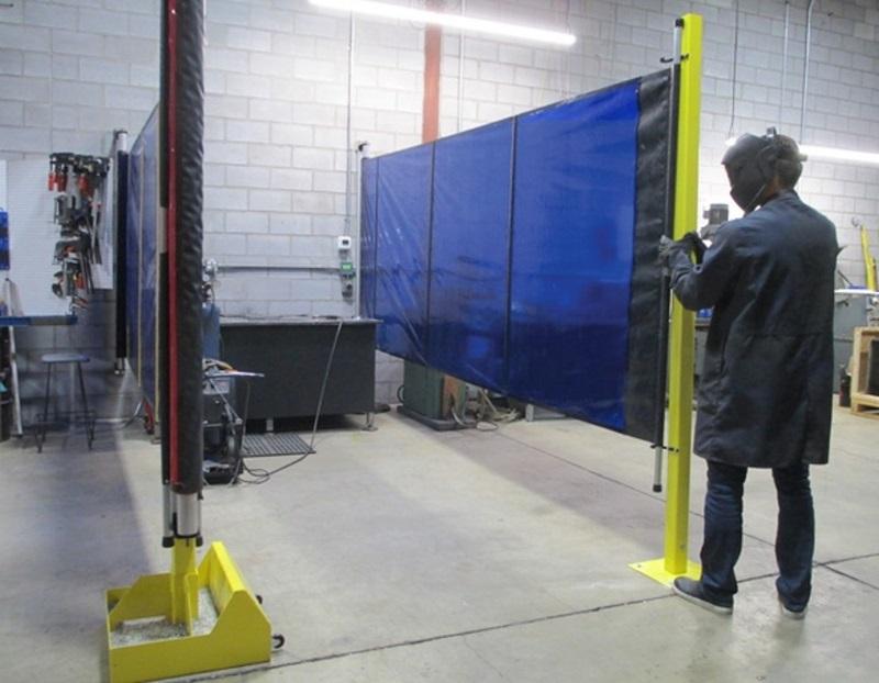 Retractable weld screen protects welding shop employees